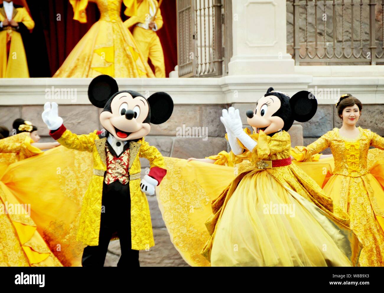 Entertainers dressed in Mickey Mouse and Minnie Mouse costumes perform ...