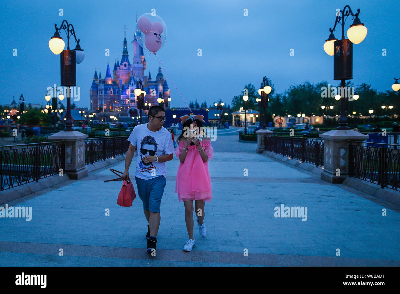 A Chinese couple holds up a Mickey Mouse balloon at the Shanghai Disney ...