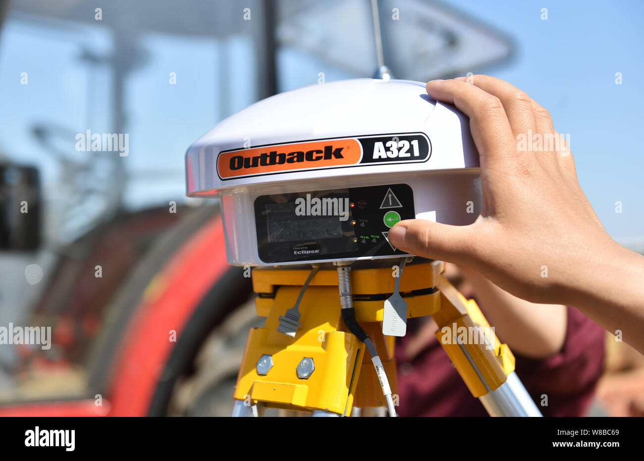 Chinese technicians operate a satellite signal receiver next to a ...
