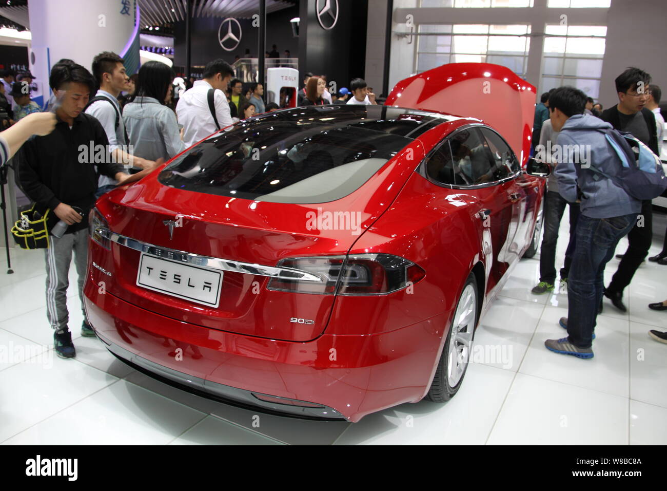 Visitors look at a Tesla Model S electric car on display during the ...