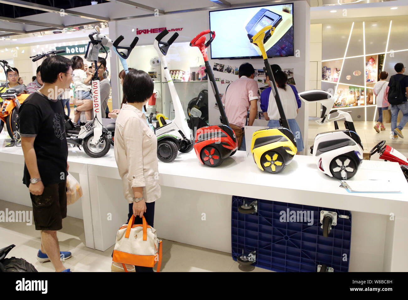 --FILE--Chinese visitors look at self-balancing electric scooters at a ...