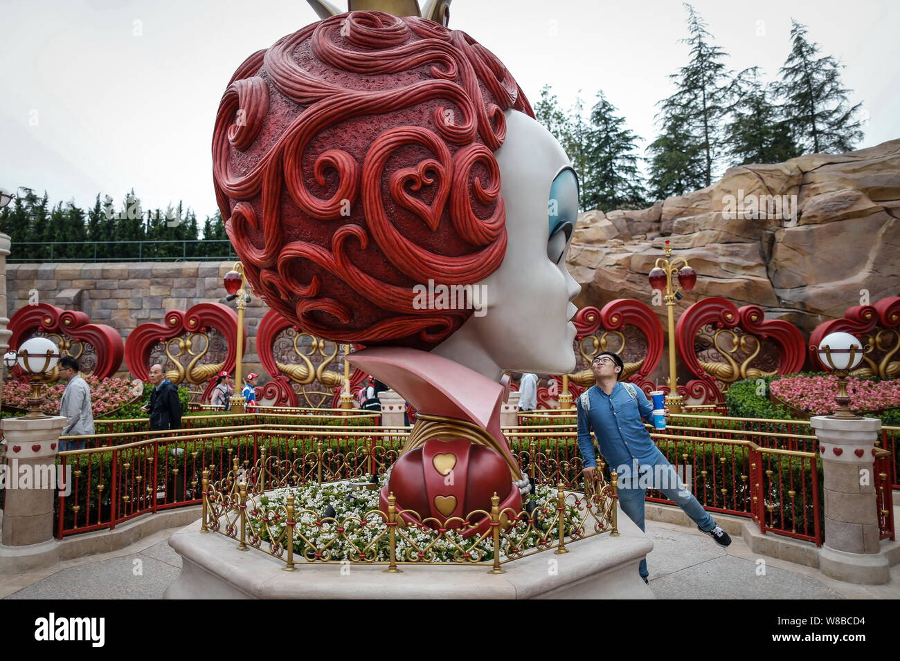 A visitor poses for photos at the "Alice in Wonderland" maze in the ...