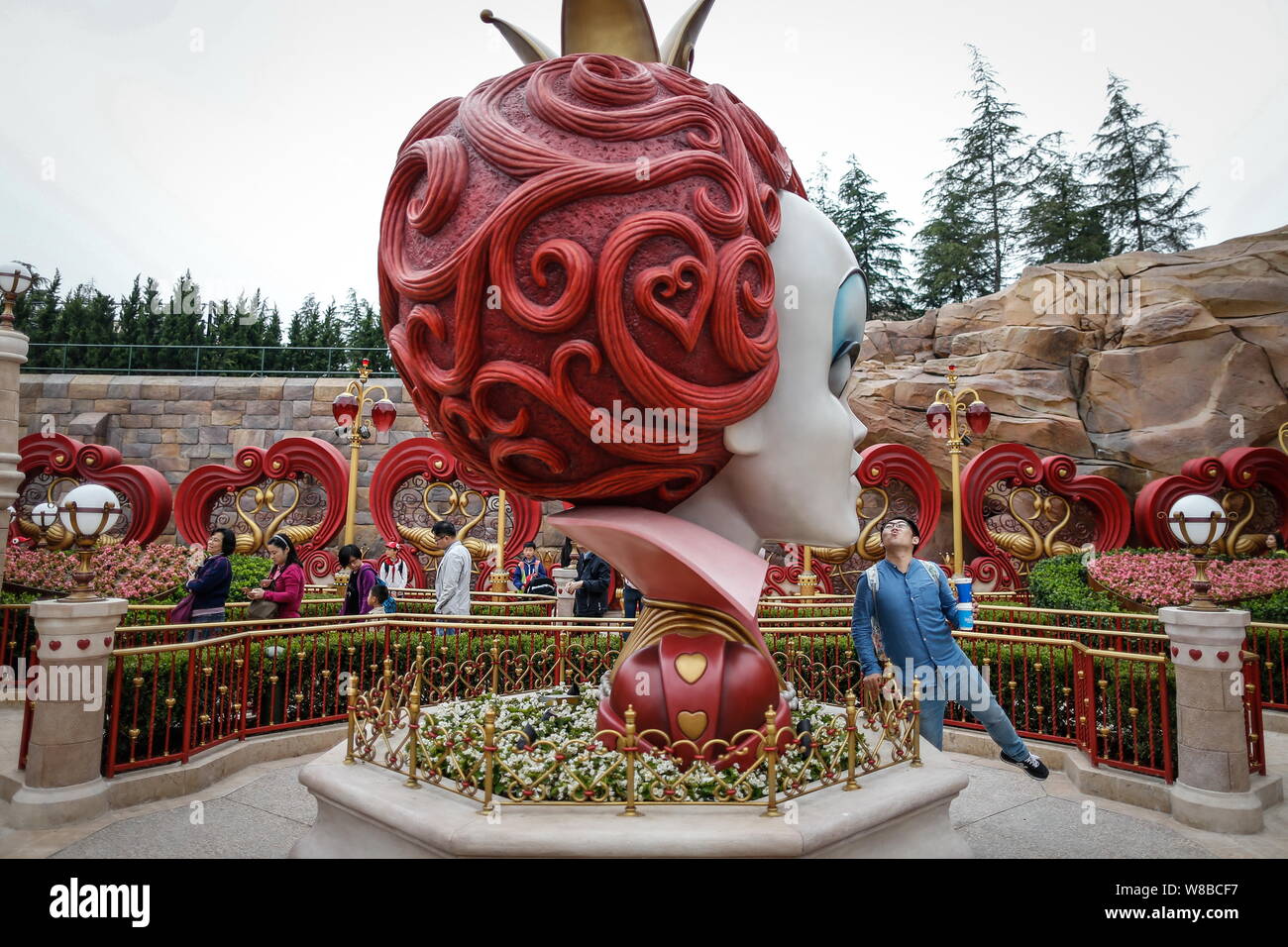 A visitor poses for photos at the "Alice in Wonderland" maze in the ...