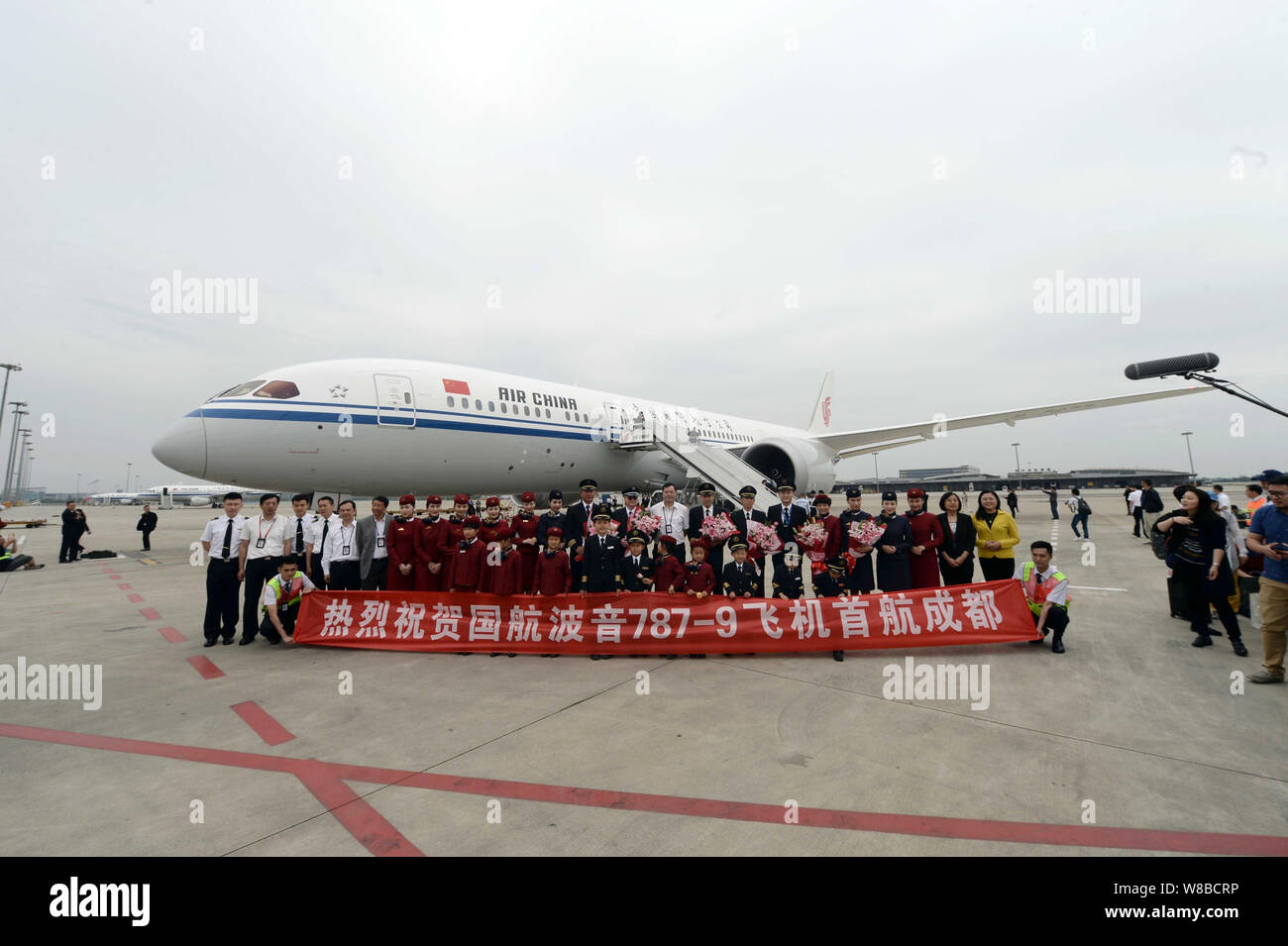Air crew members pose for photos in front of Air China's first Boeing ...