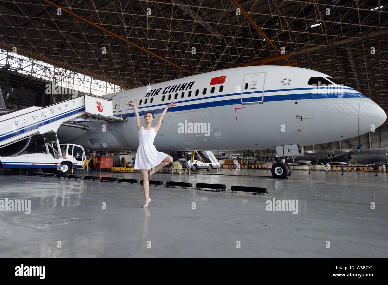 A dancer performs in front of Air China's first Boeing 787-9 Dreamliner ...