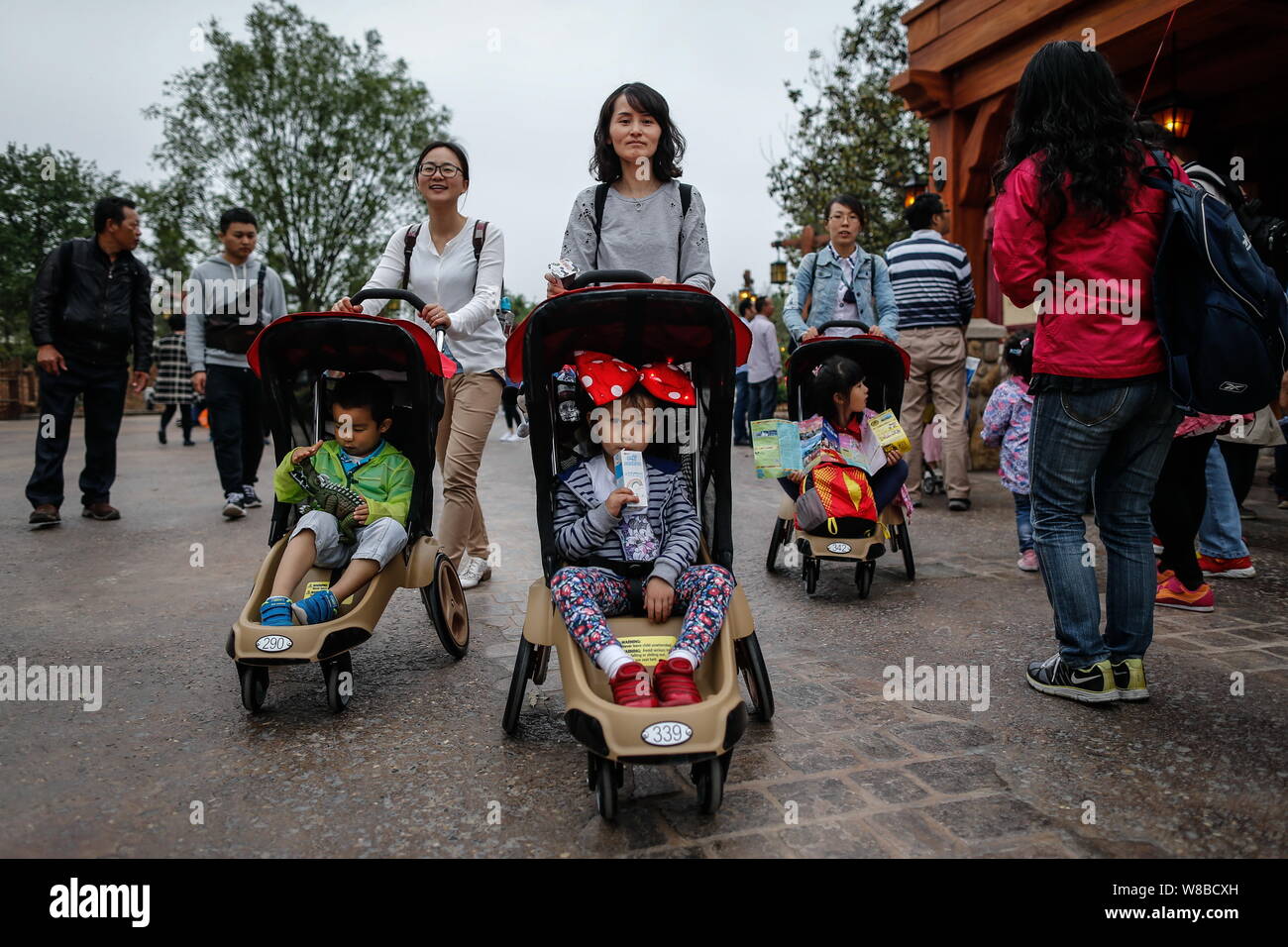 Chinese parents push baby strollers carrying their children in the ...