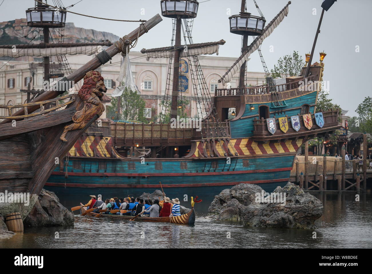 Visitors row a boat past a pirate ship in the Shanghai Disneyland at ... Visitors row a boat past a pirate ship in the Shanghai Disneyland at ...