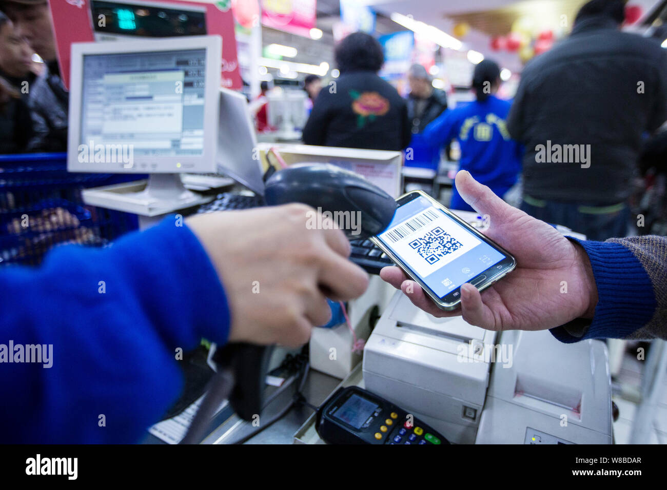 --FILE--A customer has the barcode on his smartphone scanned by a ...