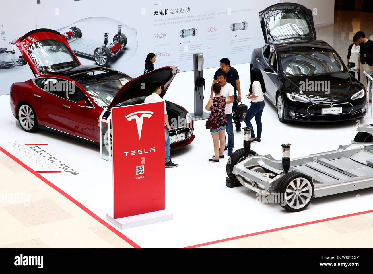 --FILE--Chinese shoppers look at Tesla Model S electric cars on display ...
