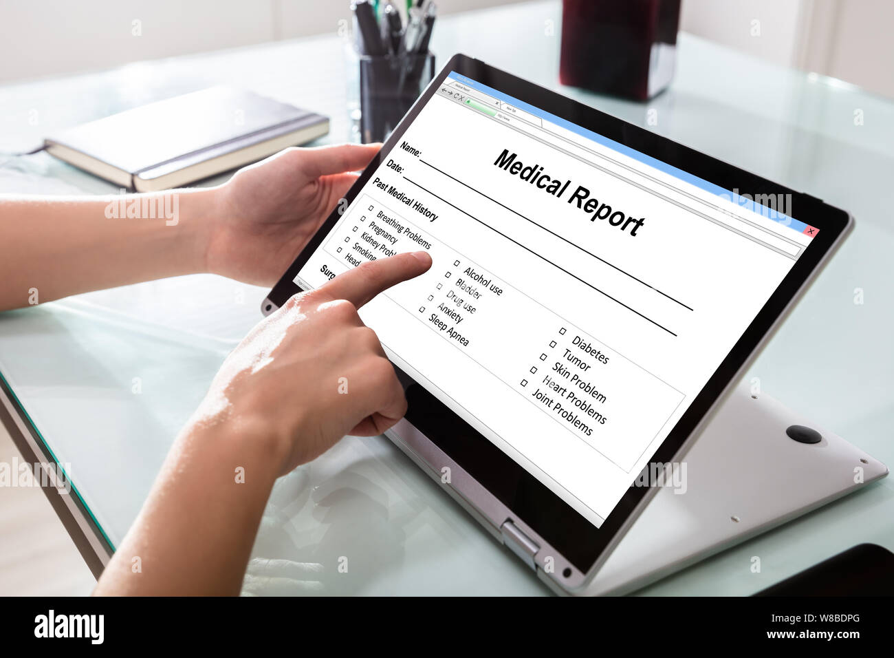 Person's Hand Showing Patient Information Form On Laptop Over Desk ...