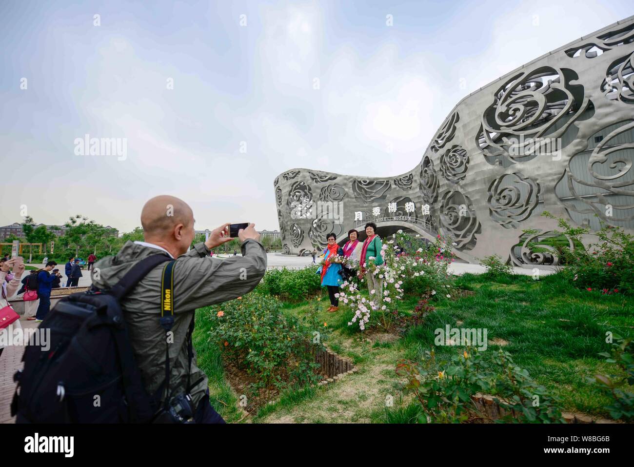Visitors pose for photos in front of the Chinese Rose Museum, which is ...
