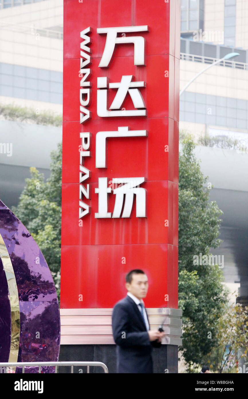 --FILE--A Chinese security guard walks past a signboard at a Wanda ...