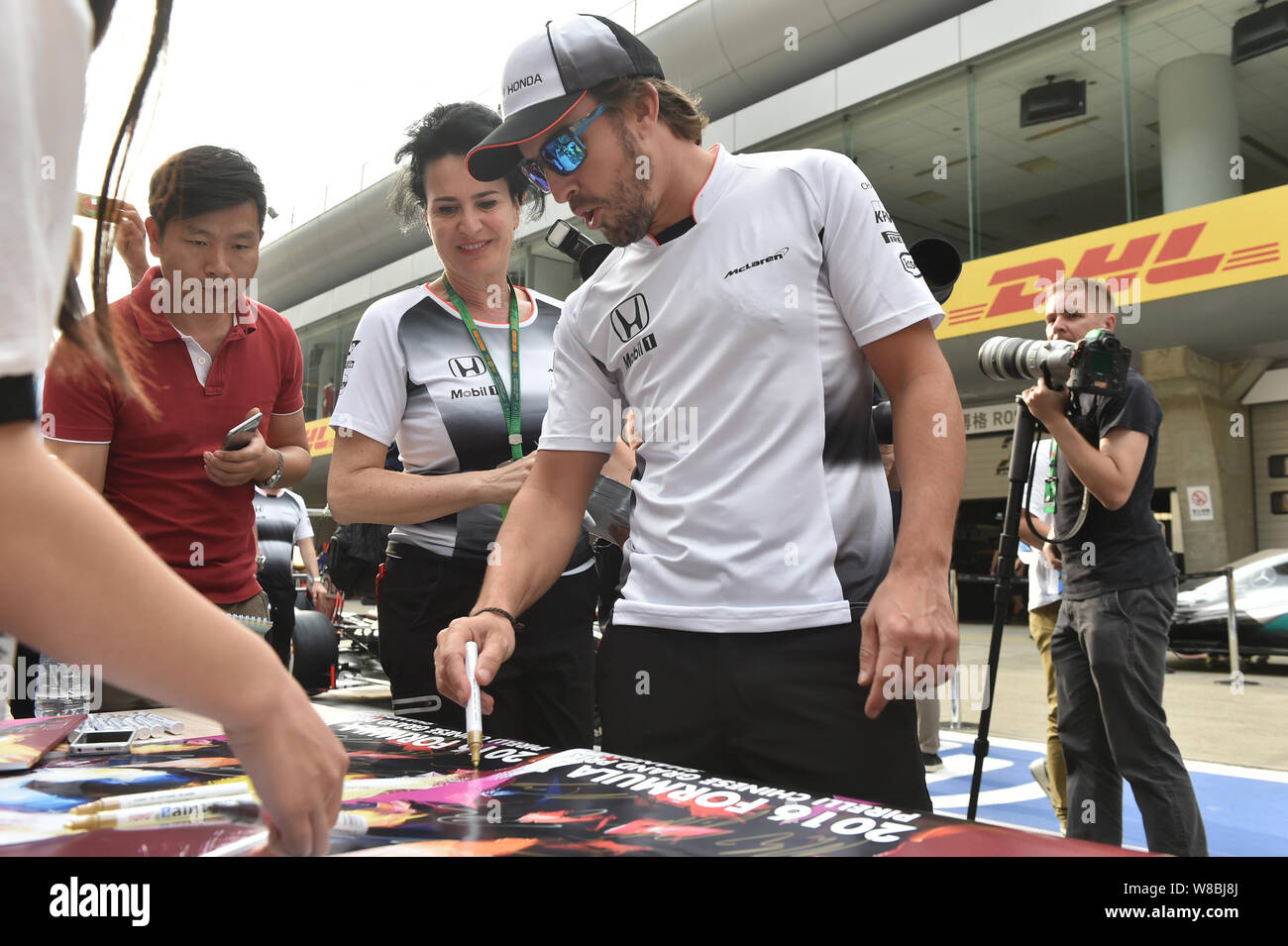 Spanish F1 driver Fernando Alonso of McLaren-Honda signs autographs for ...