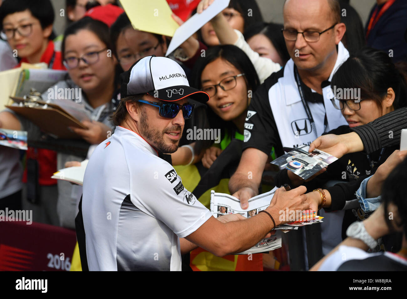 Spanish F1 driver Fernando Alonso of McLaren-Honda signs autographs for ...