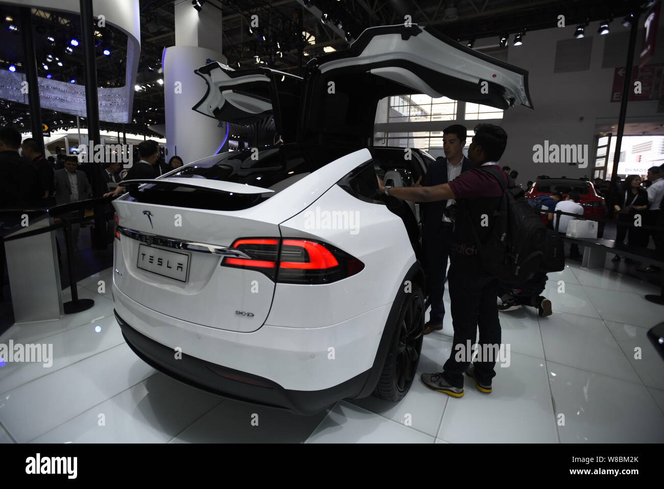 Visitors look at a Tesla Model X electric car on display during the ...