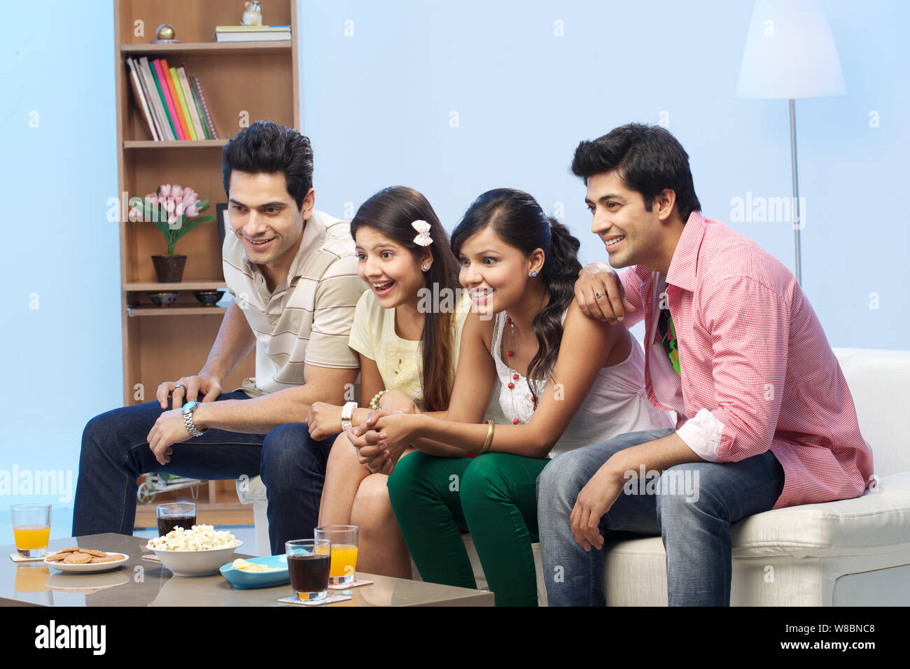 Friends watching tv Stock Photo - Alamy
