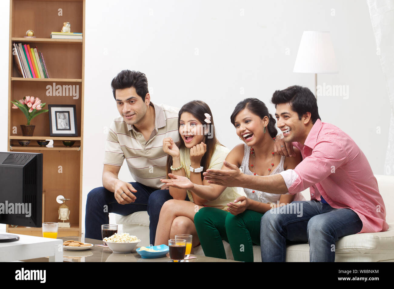 Friends watching tv Stock Photo - Alamy