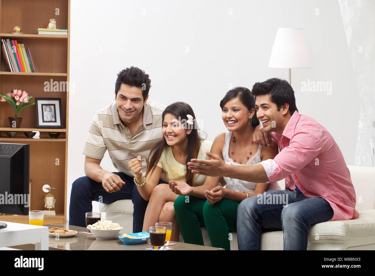 Friends watching tv Stock Photo - Alamy