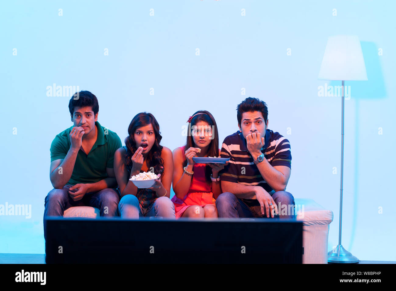 Friends watching tv Stock Photo - Alamy