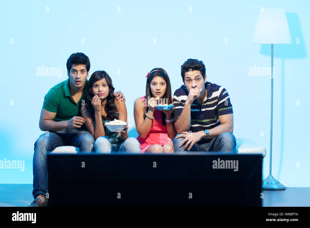 Friends watching tv Stock Photo - Alamy