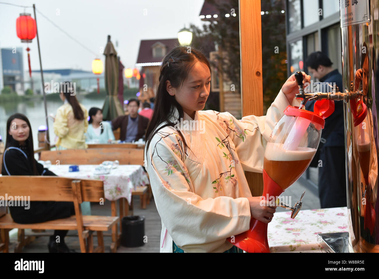 A Chinese waiter waitress wearing an ancient Chinese costume prepares ...