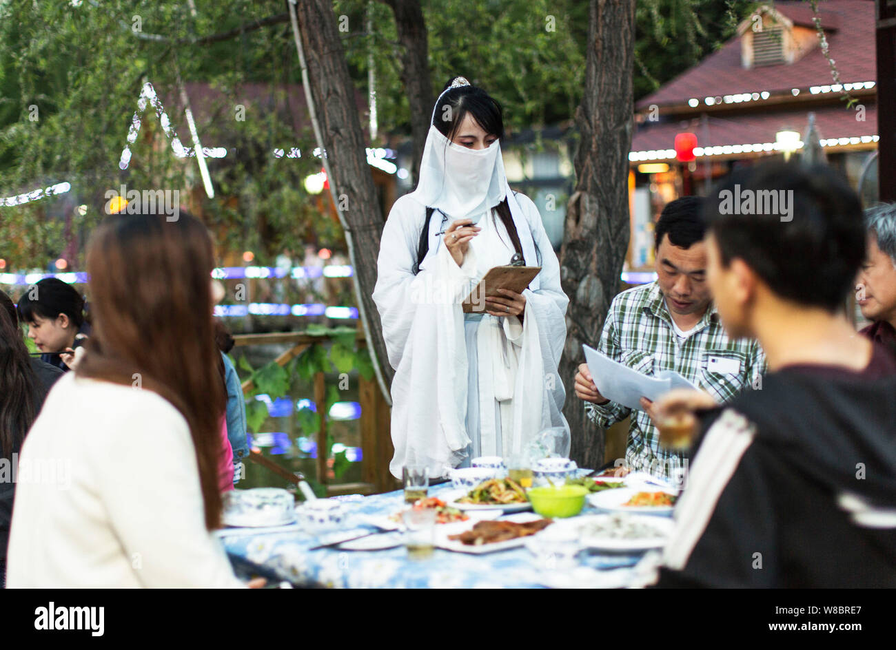 A Chinese waiter waitress wearing an ancient Chinese costume orders ...