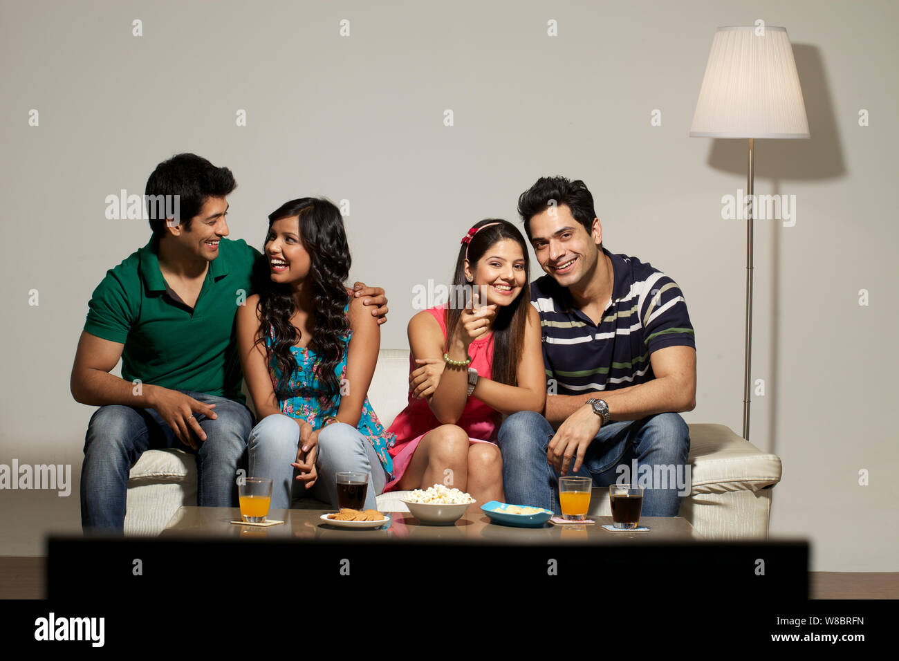 Friends watching tv Stock Photo - Alamy