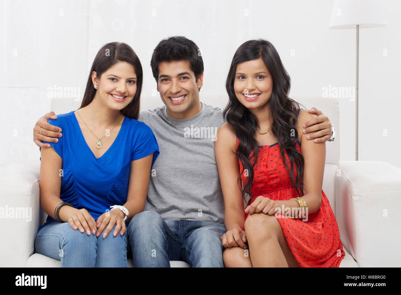 Portrait of three friends sitting together smiling Stock Photo - Alamy