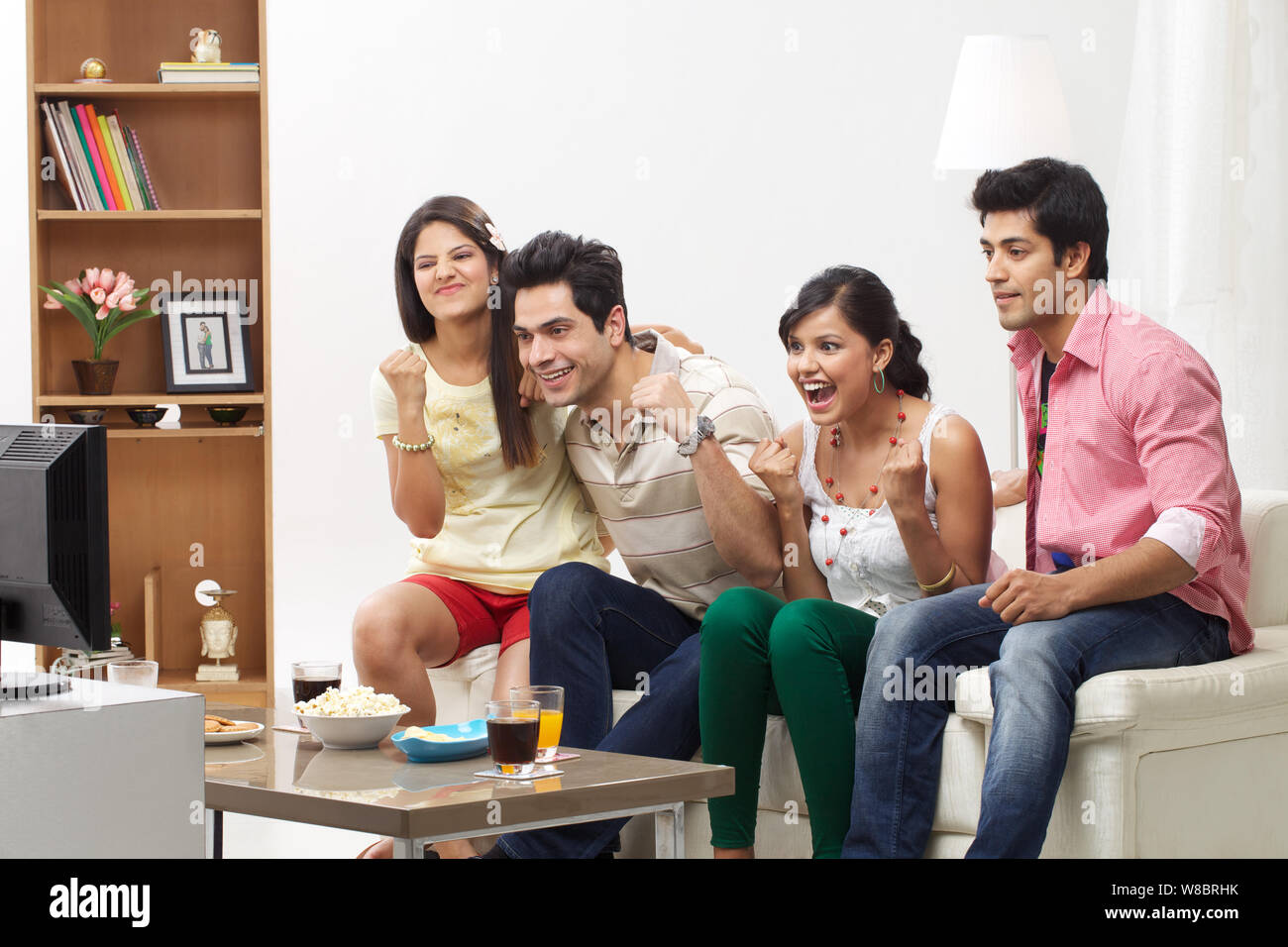 Friends watching tv Stock Photo - Alamy
