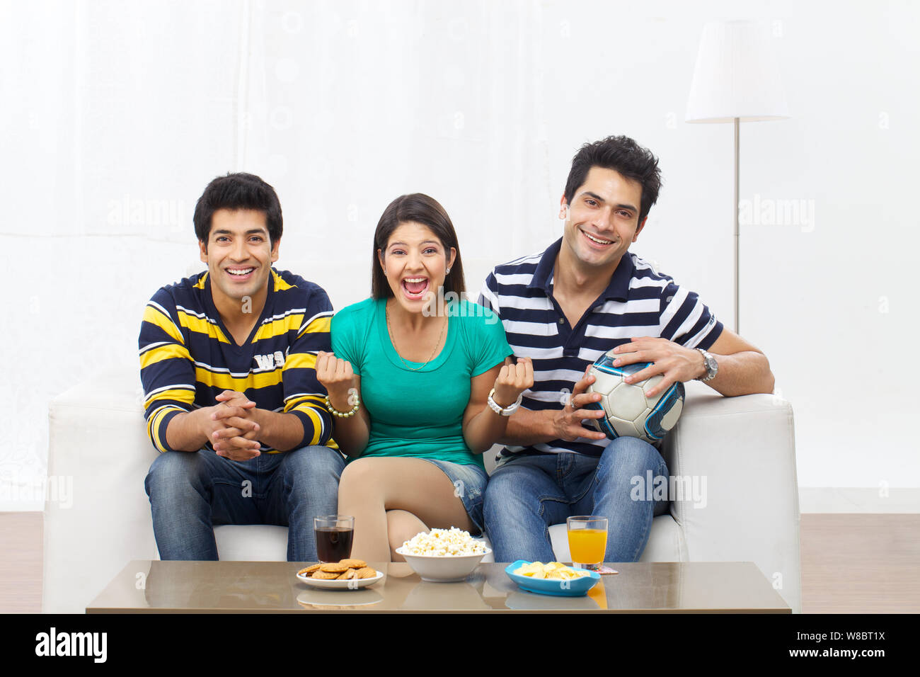 Friends watching tv Stock Photo - Alamy