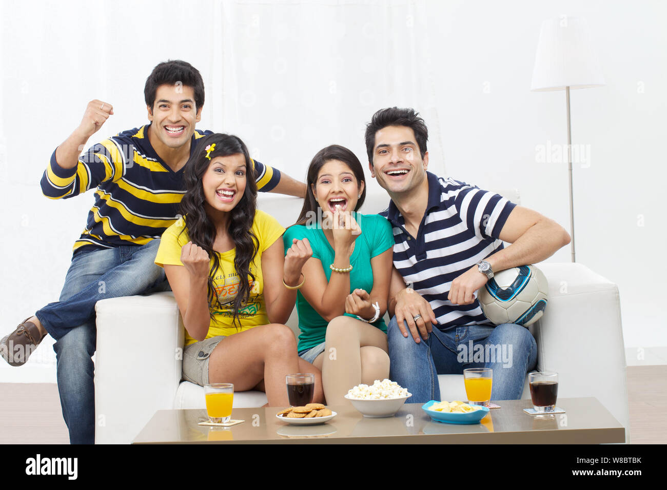 Friends watching tv Stock Photo - Alamy