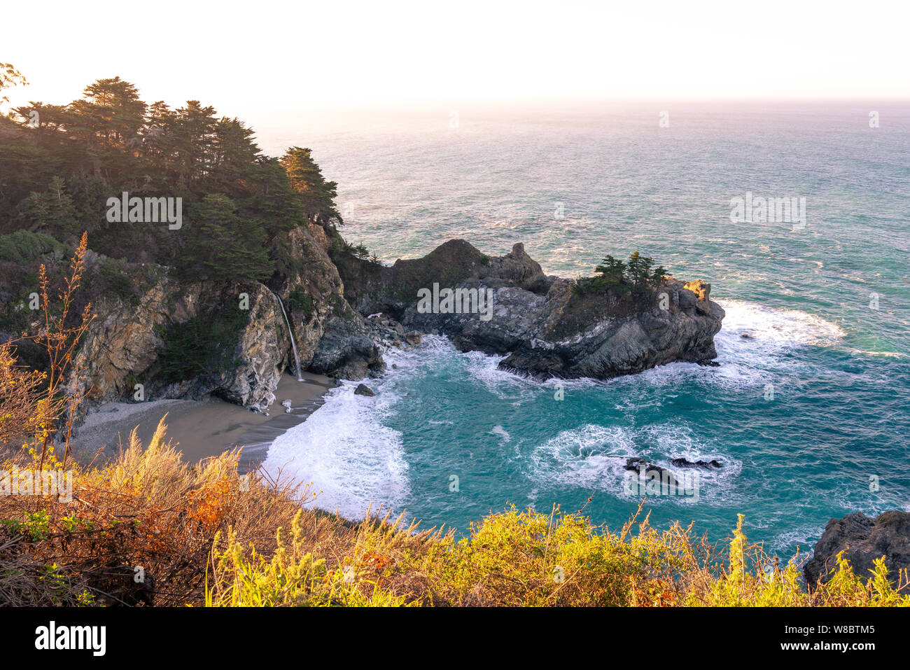 First morning light washing over the hillside cliffs at McWay Falls ...
