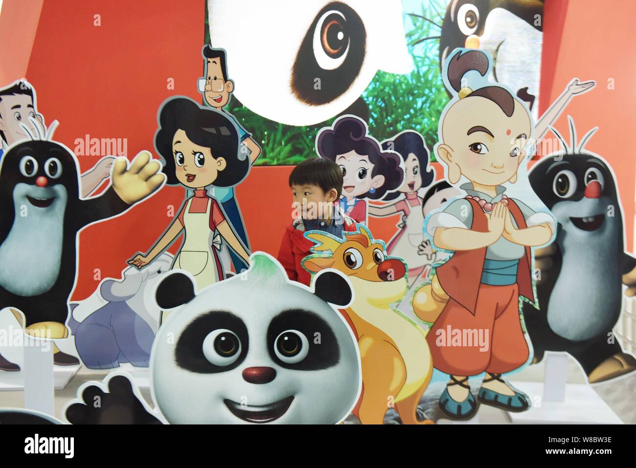 A young boy walks through cutouts of cartoon figures during the China ...