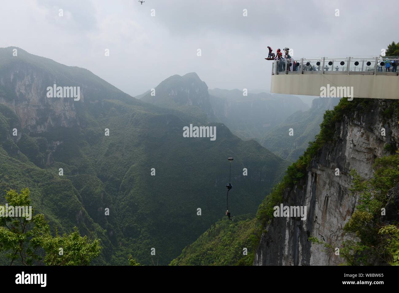 Contestants jump off the glass cantilever bridge on the cliff during ...