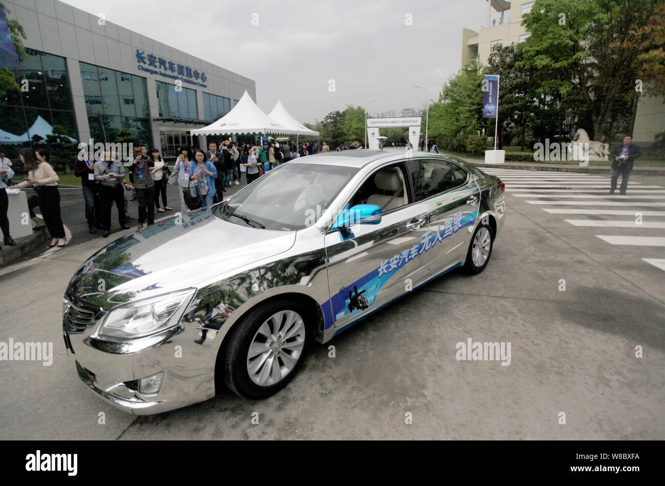 People take pictures of a self-driving car produced by Changan which ...