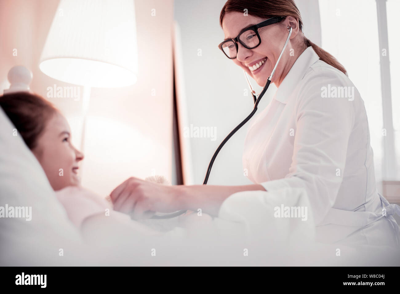 Cheerful positive woman treating her young patient Stock Photo - Alamy