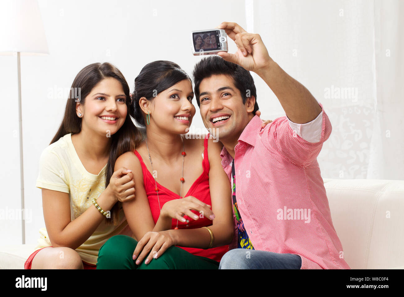 Happy friends photographing sitting hi-res stock photography and images ...