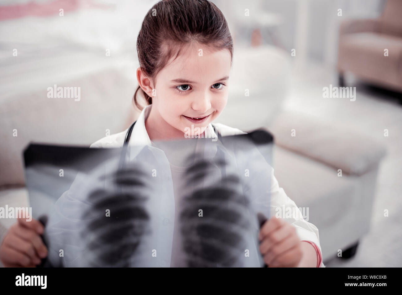 Cheerful smart girl thinking about the diagnosis Stock Photo - Alamy