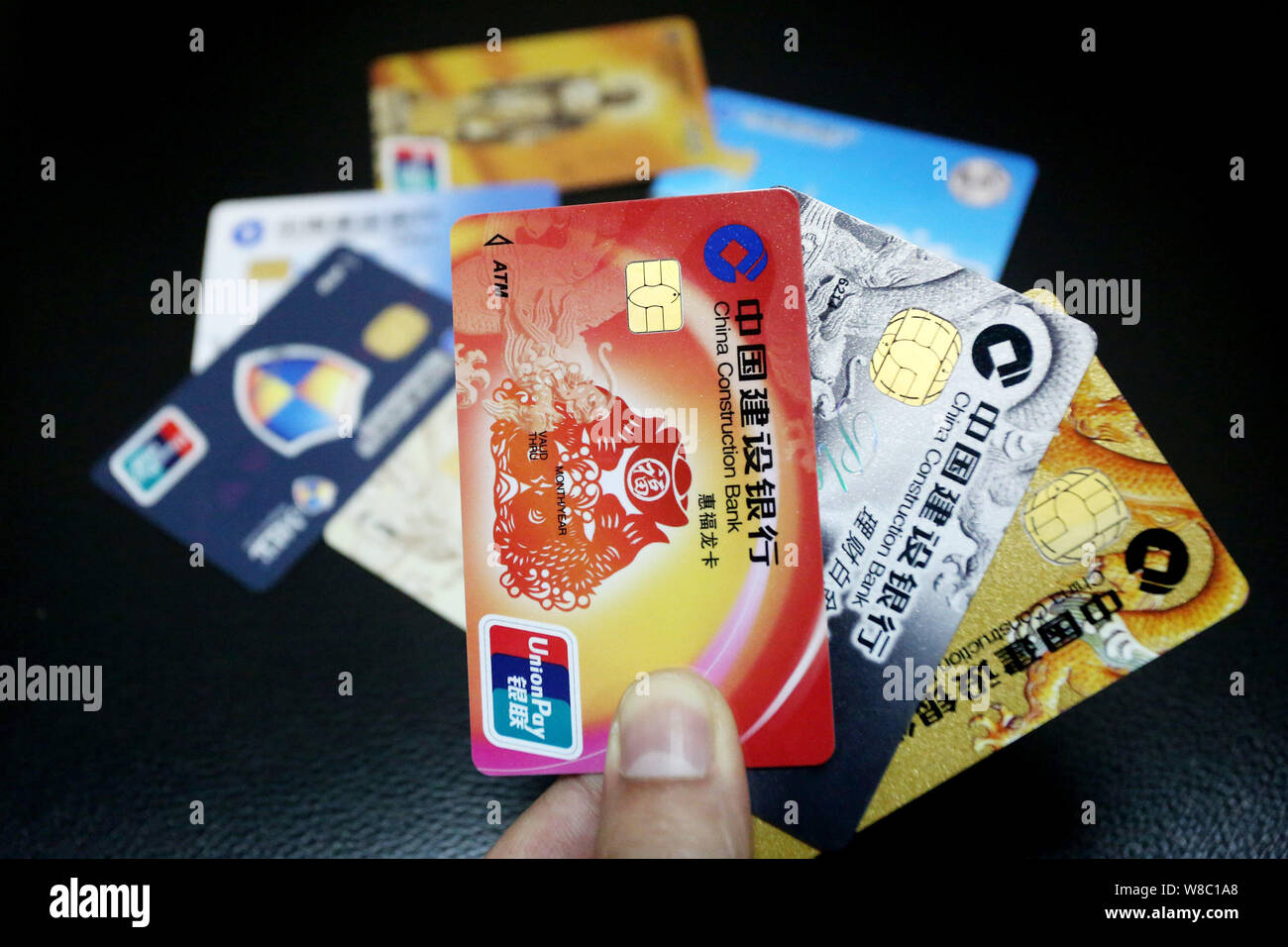 --FILE--A Chinese resident shows his debit cards and other bank cards ...