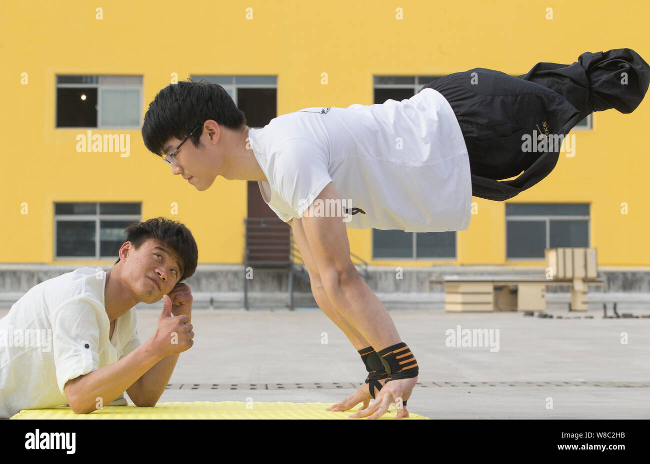 Legless Chinese man Shen Dacheng, right, supports his body with two ...