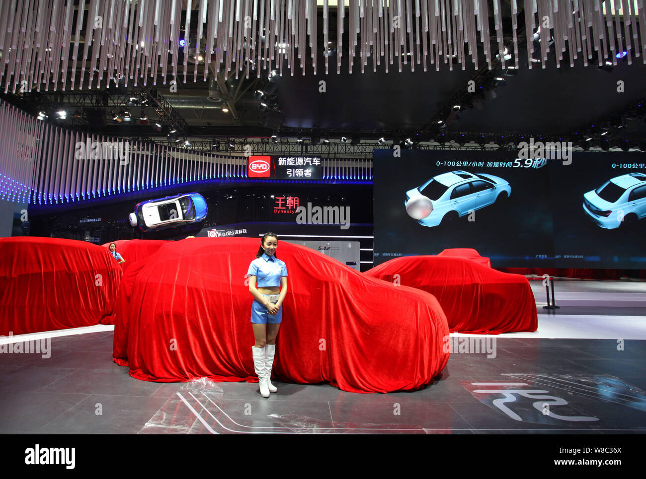 Showgirls pose with veiled news cars of BYD in preparation for the 14th ...
