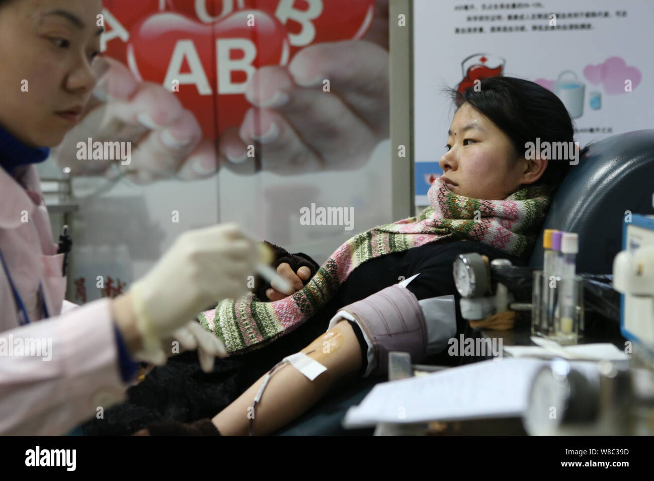 --FILE--A young Chinese woman donates her blood on a blood donation bus ...