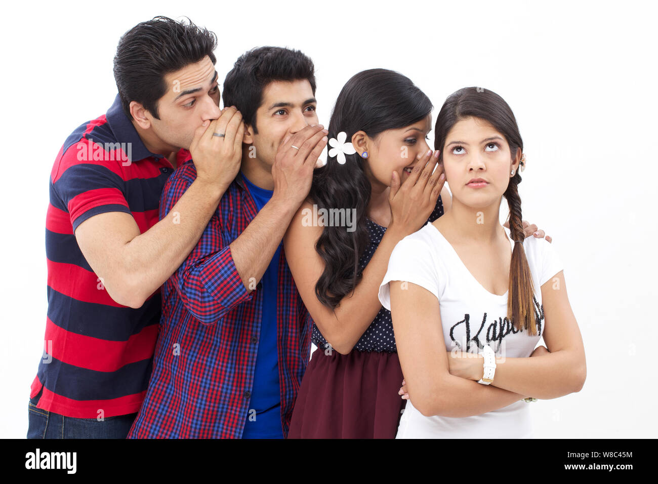 Four friends whispering into each others ears Stock Photo - Alamy