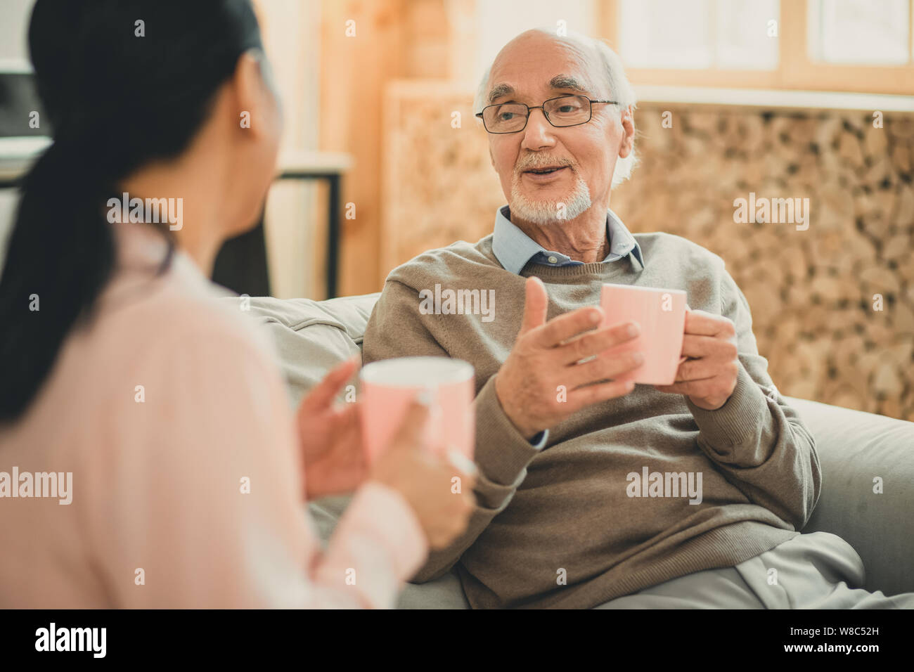 Old man having friendly conversation with his female friend Stock Photo ...