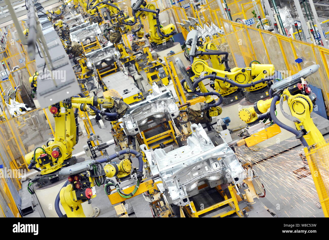 --FILE--Robot arms weld car parts at an auto plant of Dongfeng Peugeot ...