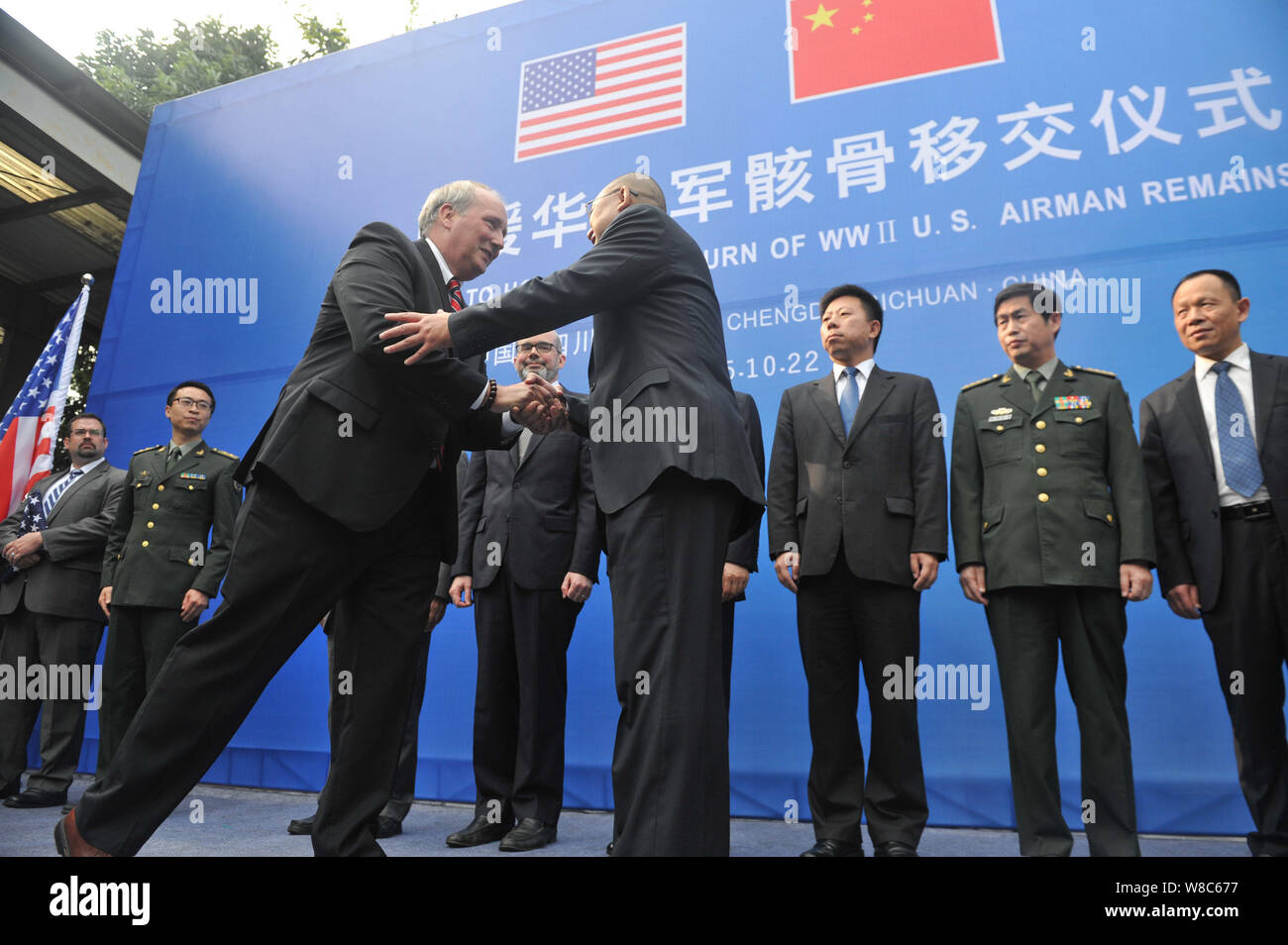 Chinese and American officials shake hands during a ceremony to honor ...
