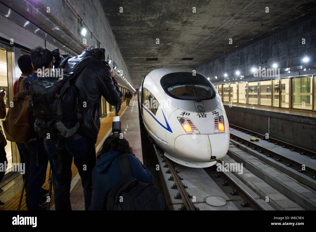 Passengers take photos of a CRH (China Railway High-speed) bullet train ...