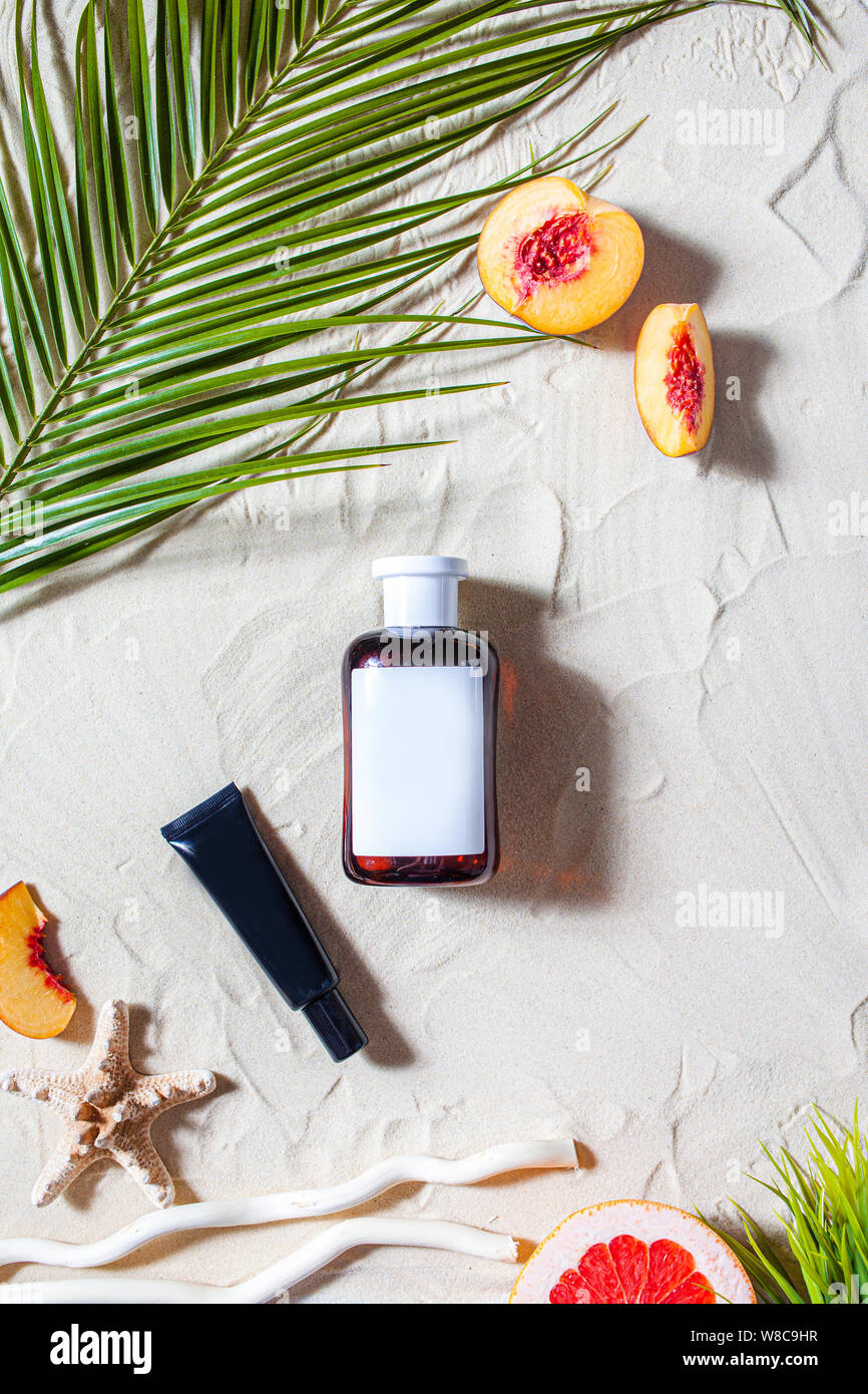 Safe sun. Skin care. A tube and can of cream lies on the beach sand ...