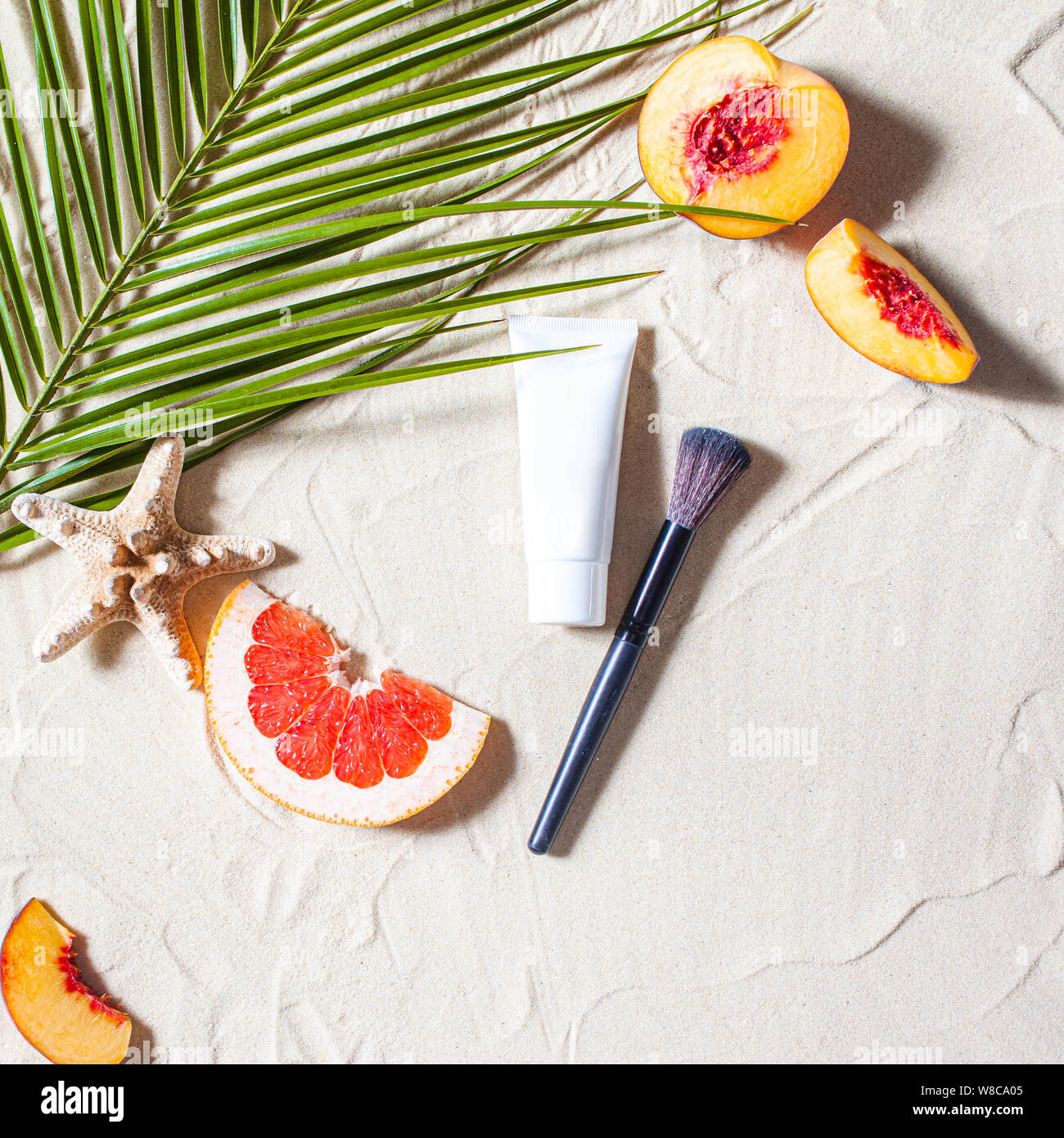 Safe sun. Skin care. A tube of cream and brush lies on the beach sand ...
