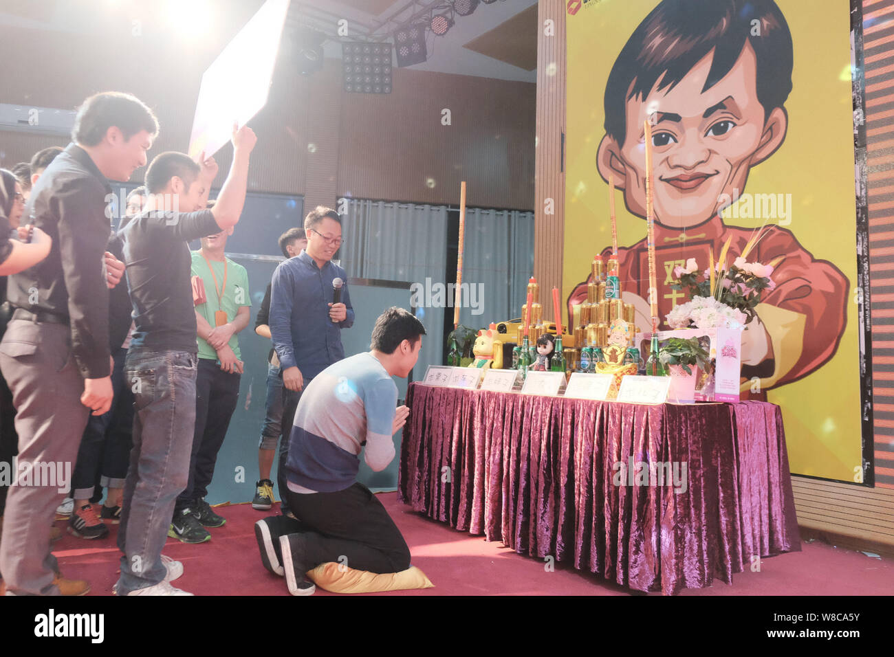A Chinese employee of an e-commerce company kneels down in front of a ...
